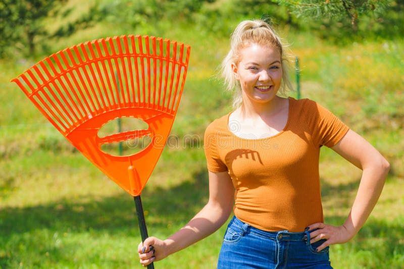 Woman with rake in garden stock image. Image of yard - 358720639