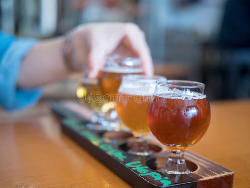Woman Reaching for Flight of Beers with Focus on Front Beer Stock Photo ...