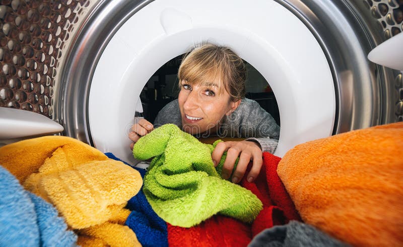 Woman Reaching Inside a Washing Machine or Dryer at Laundry Stock Photo ...