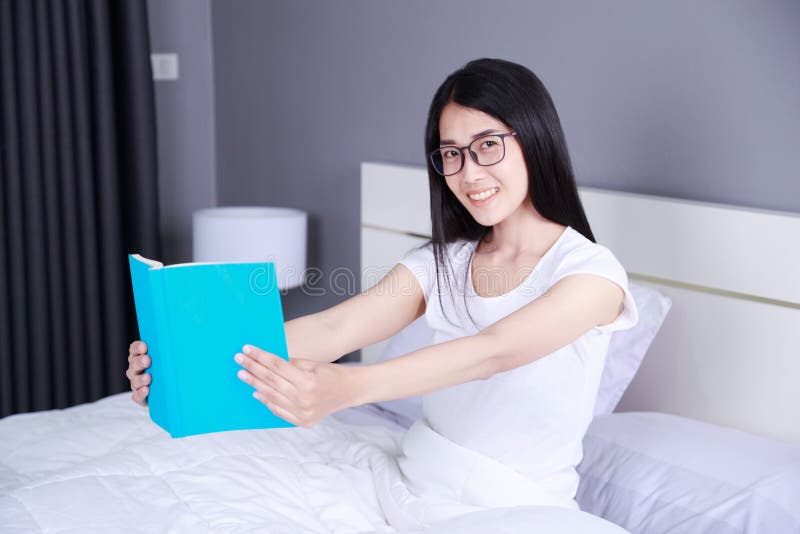 Woman Reading a Book on Bed in Bedroom at Home Stock Photo - Image of ...