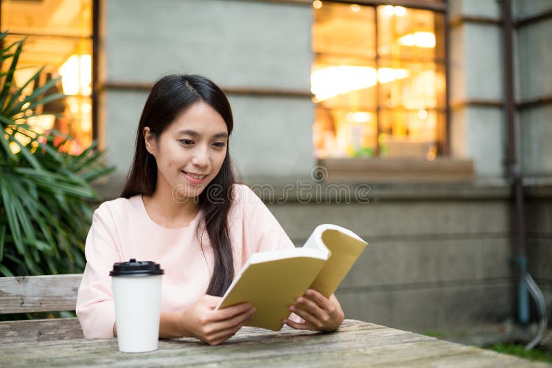 Woman reading book at cafe stock photo. Image of eating - 67961122