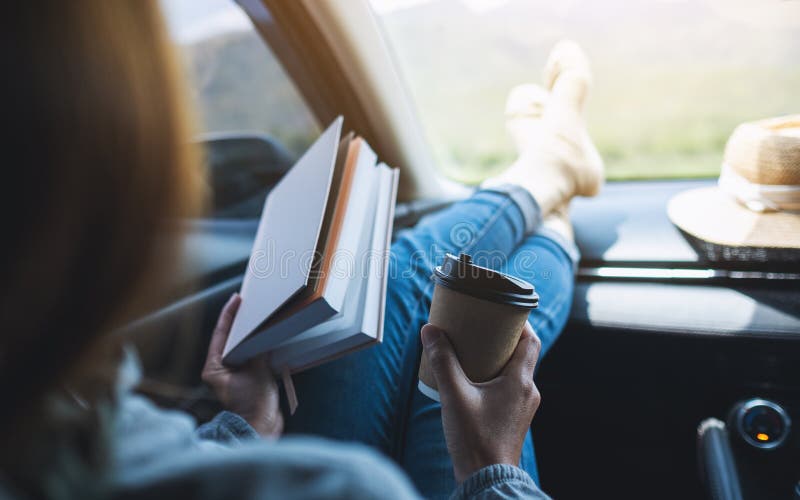 A Young Woman Reading Book and Drinking Coffee in the Car Stock Photo ...