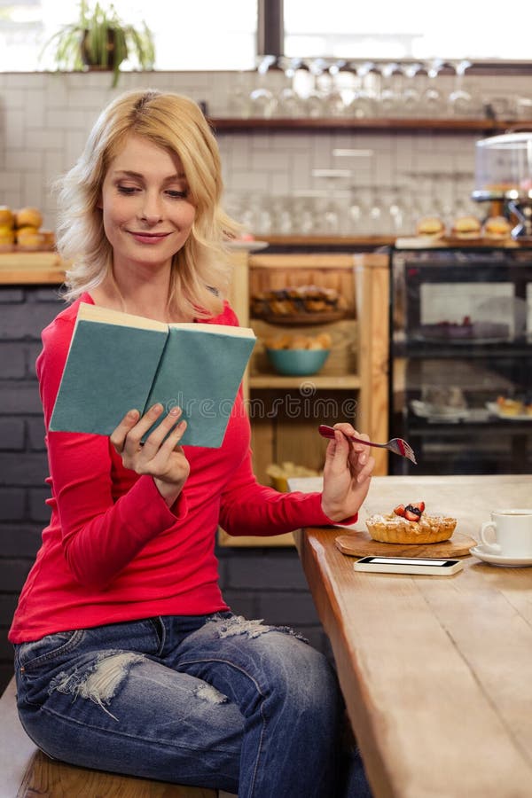 Woman Reading a Book and Eating a Cake Stock Image - Image of clothing ...