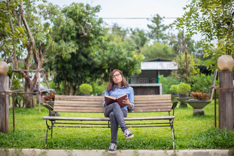 Woman Reading Book on Park Bench. Stock Image - Image of book ...