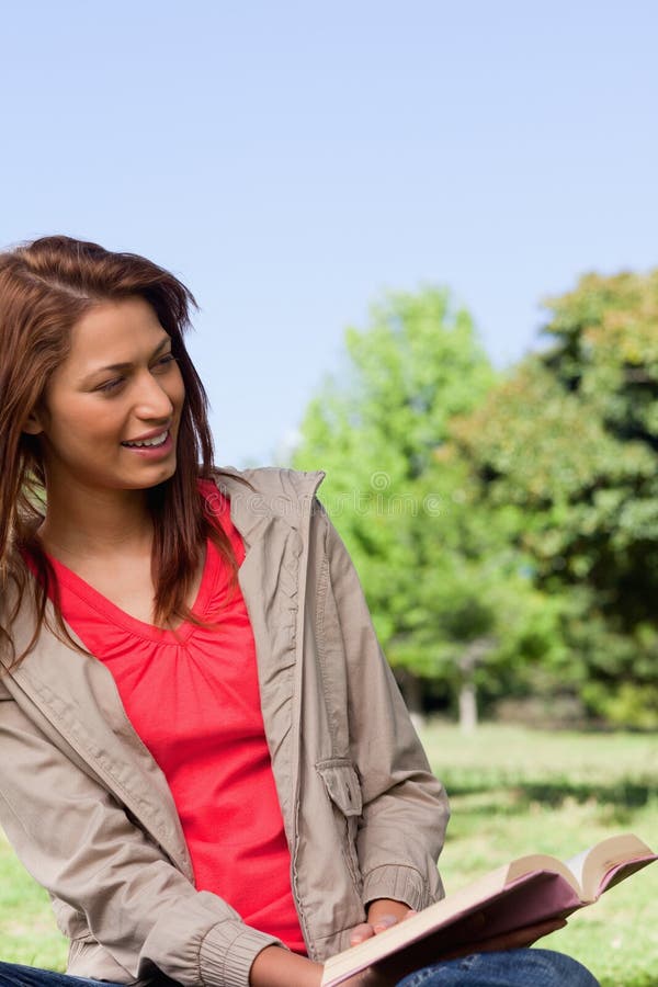Woman Reading a Book while Sitting Down in a Bright Park Stock Image ...