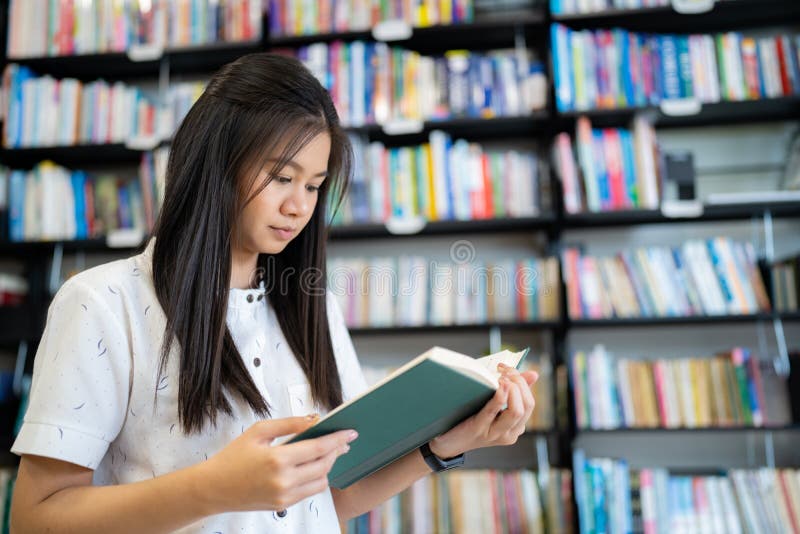 A Woman is Reading a Book in the University Library Stock Photo - Image ...