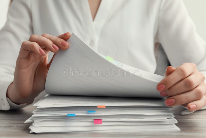 Woman Reading Documents at Wooden Table in Office, Closeup Stock Image ...