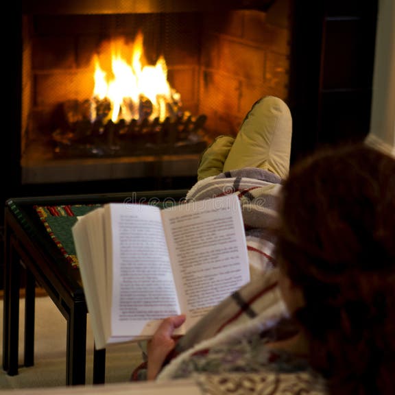 Woman reading by fireplace stock image. Image of cozy - 23316647