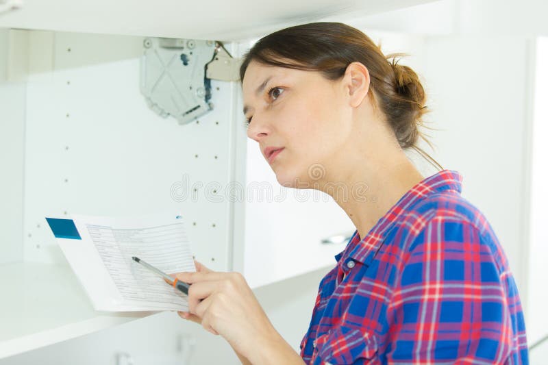 Woman Reading Manual on Fitting Cupboard Stock Image - Image of fitter ...