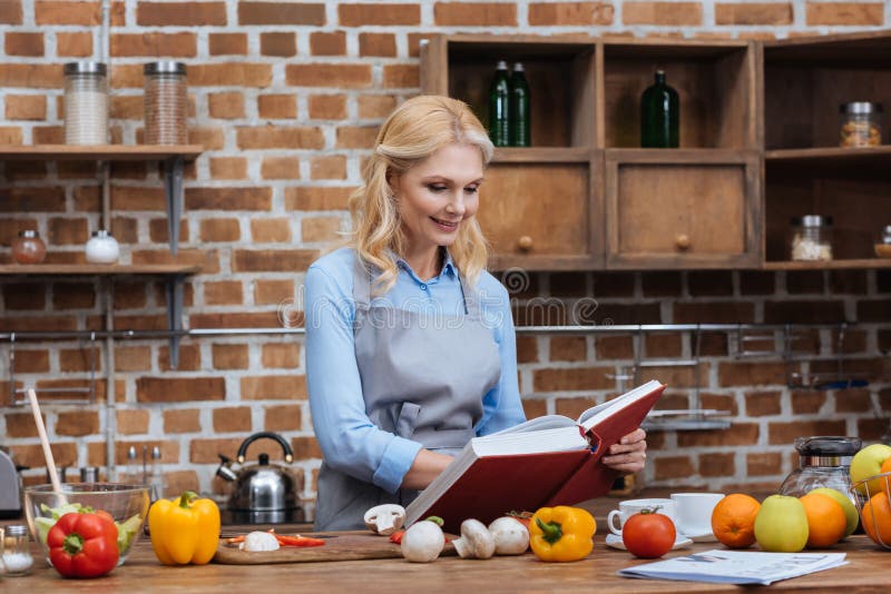 Woman reading recipe book stock photo. Image of eating - 119814852