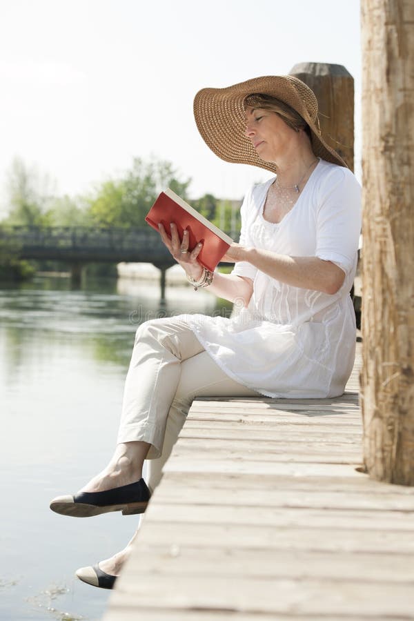 Woman reading by the river stock photo. Image of happiness - 25945302