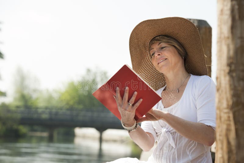 Woman reading by the river stock photo. Image of happiness - 25945302