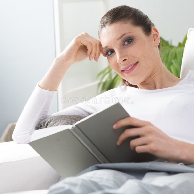 Woman reading on sofa stock image. Image of beautiful - 39559713