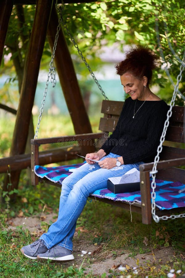 Woman reading in a swing stock photo. Image of amused - 233063928