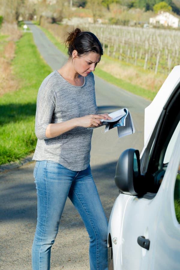 Woman Reading Vehicle Owners Manual by Broken Down Car Stock Image ...