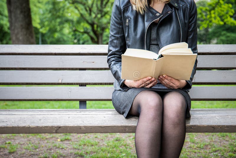 Woman and Man Reads Book Sitting on a Bench at the Park Stock Photo ...