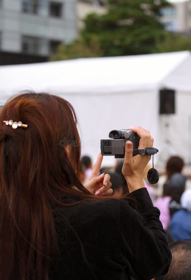 Woman recording an event stock photo. Image of device - 1423940