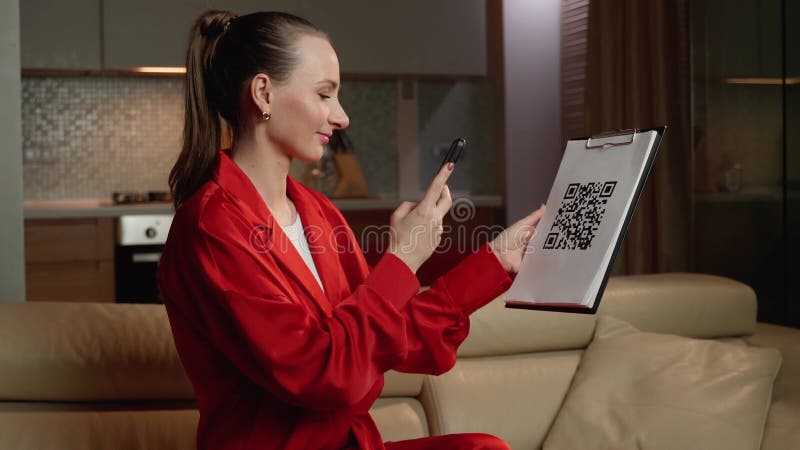 Woman in Red Attire Scanning QR Code with Smartphone in a Cozy Living ... Woman in Red Attire Scanning QR Code with Smartphone in a Cozy Living ...