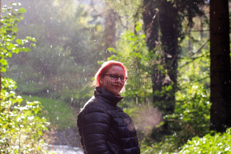 A Woman with Red Hair is Standing in a Forest with Rain Falling Stock ...