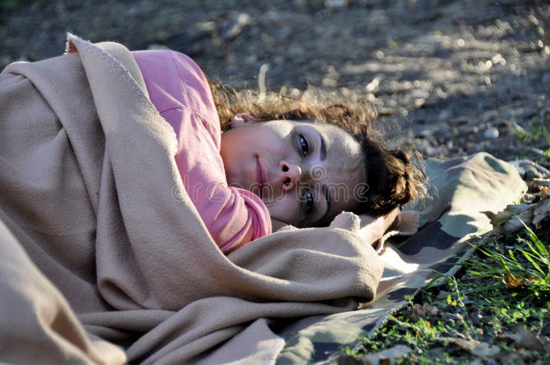 Woman Refugee Sleeping on the Ground Covered with a Rug. Stock Image ...