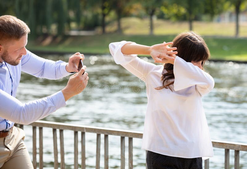Woman Refusing Man Taking Her Photo on Mobile Phone Stock Photo - Image ...