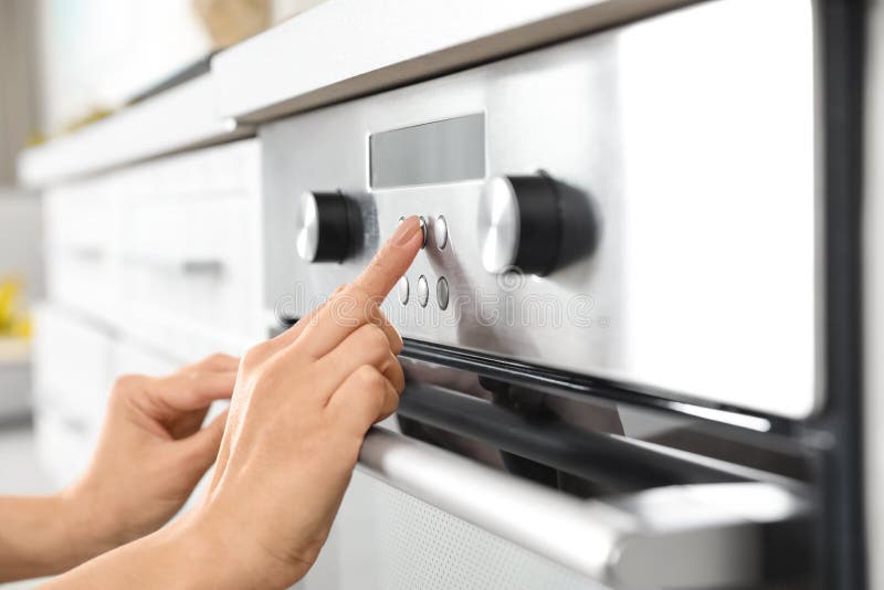 Woman Regulating Cooking Mode on Oven Panel in Kitchen Stock Image ...