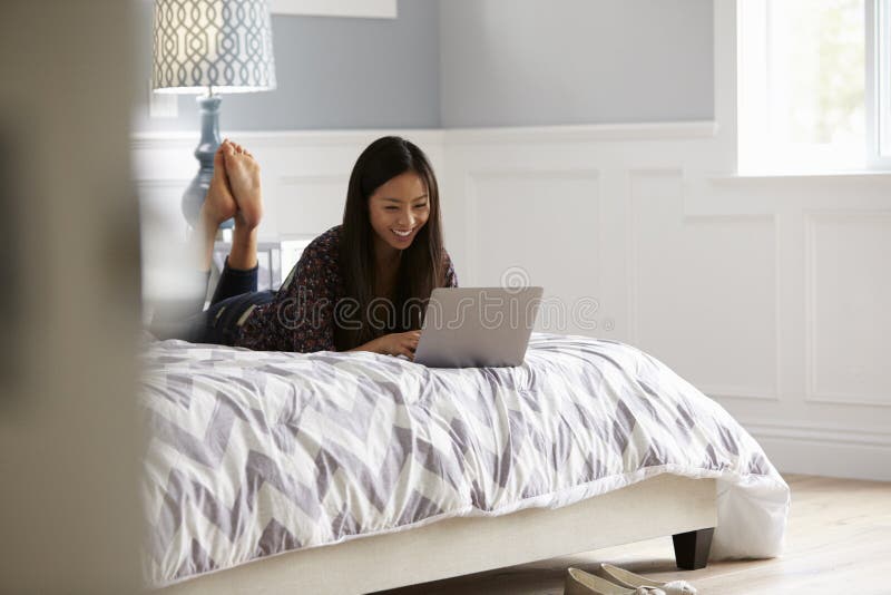 Woman Relaxing on Bed Using Laptop Computer Stock Image - Image of ...