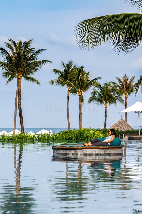 Woman Relaxing at Infinity Swimming Pool by the Beach Stock Photo ...