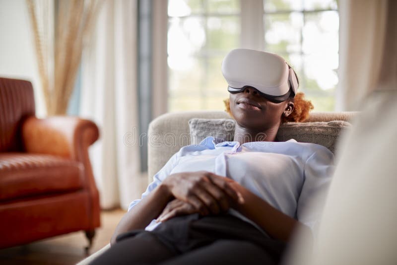 Woman Relaxing Lying on Sofa at Home Wearing VR Headset and Interacting ...