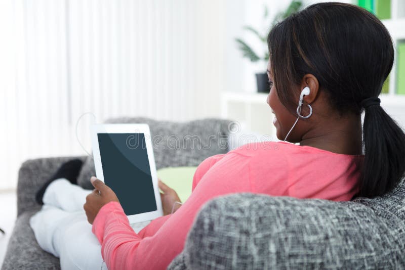 Woman relaxing with tablet stock image. Image of earphones - 30940809