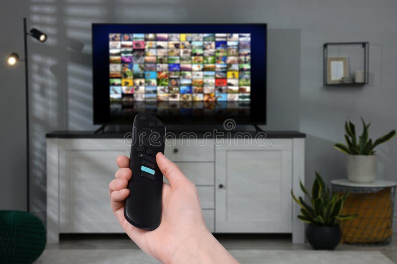 Woman with Remote Control Changing Channels while Watching TV at Home ...