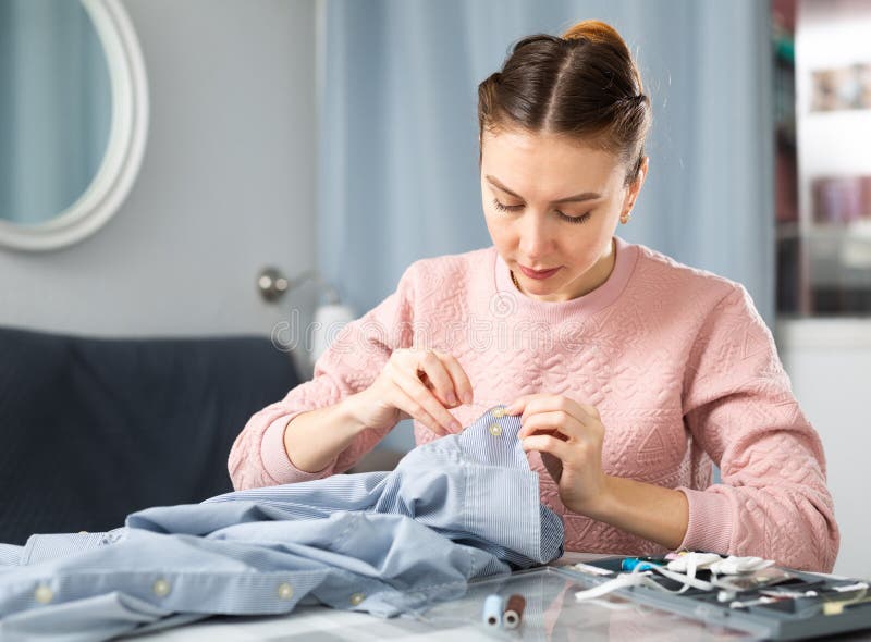 Woman Repairing Clothes with a Needle and Thread Stock Image - Image of ...