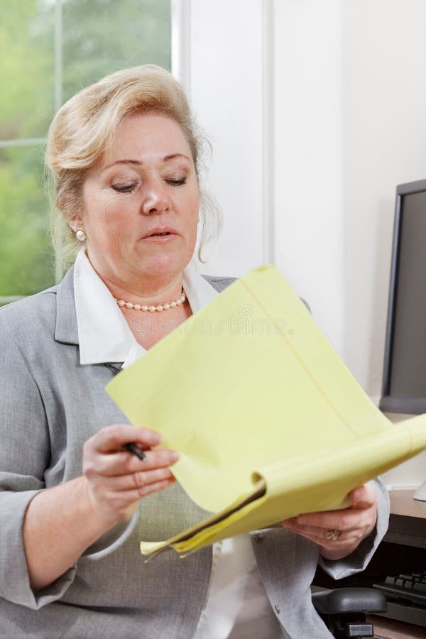 Woman reviewing notes stock image. Image of serious, paper - 21141801
