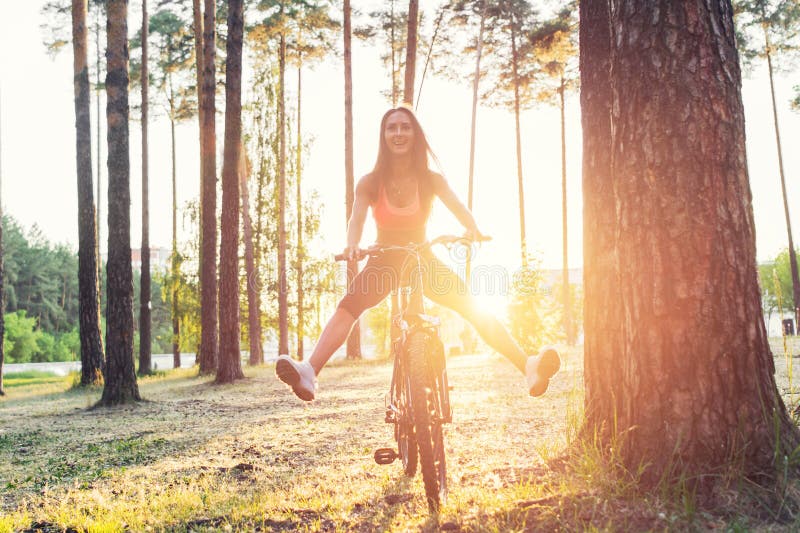Woman Riding Bicycle with Stretching Her Legs in the Air. Stock Photo ...