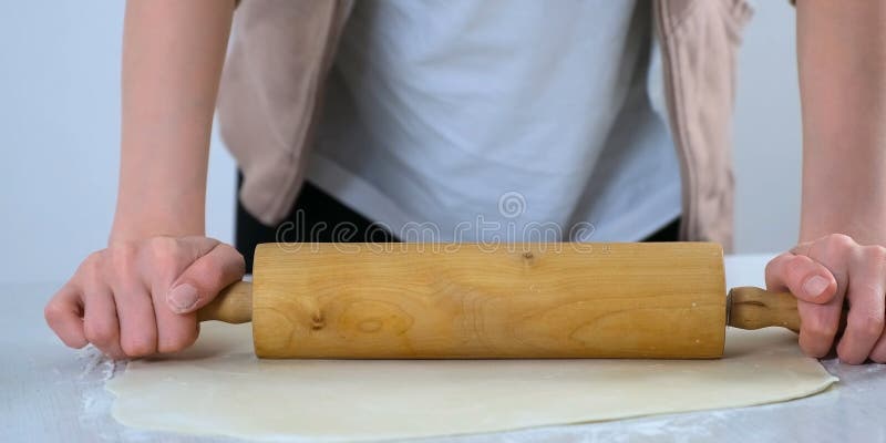 Woman is Rolling Dough for Dumpings Using Rolling Pin on Table, Hands ...