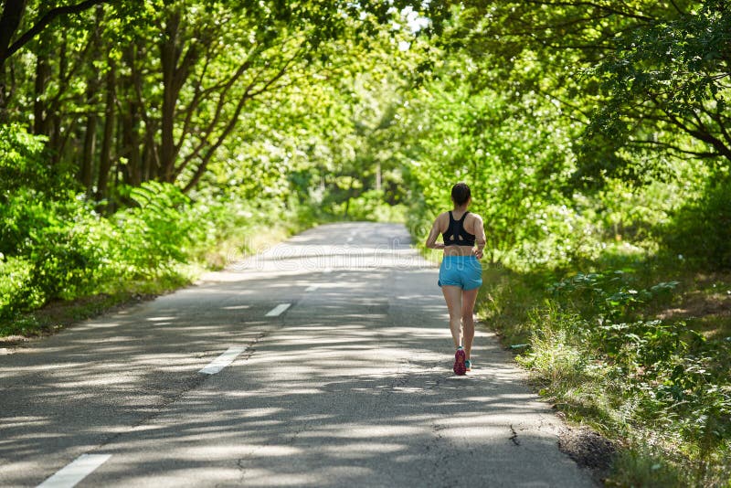 Woman Running through Forest on Asphalt Stock Photo - Image of jogger ...