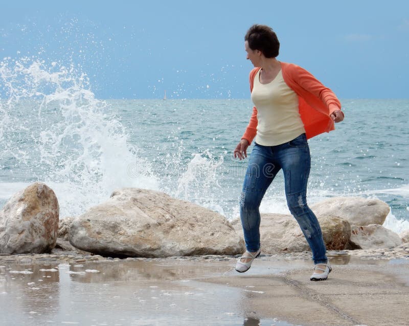Woman Running Away from the Waves Stock Image - Image of waves, woman ...