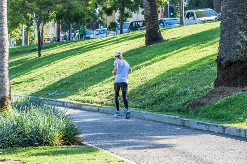 Woman running in city park editorial image. Image of motion - 94878970