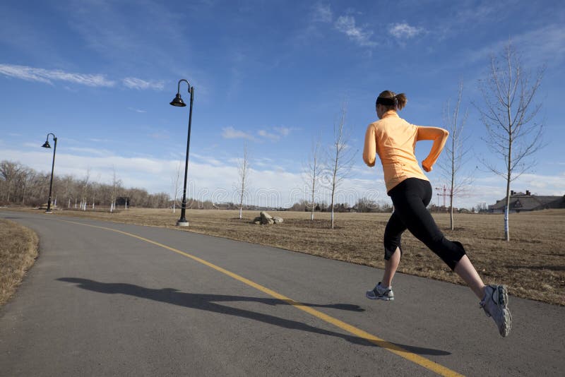 Woman running on city path stock photo. Image of orange - 13999342