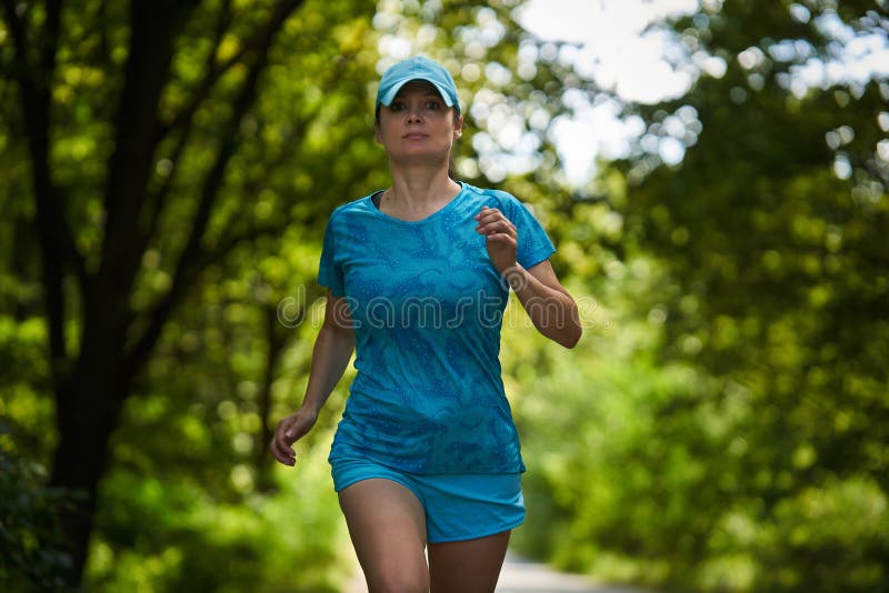 Woman Running through Forest on Asphalt Stock Image - Image of blue ...