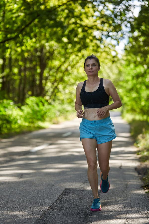 Woman Running through Forest on Asphalt Stock Photo - Image of dirt ...