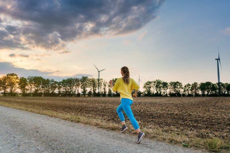 Woman Running or Jogging Down a Path in the Countryside Stock Photo ...