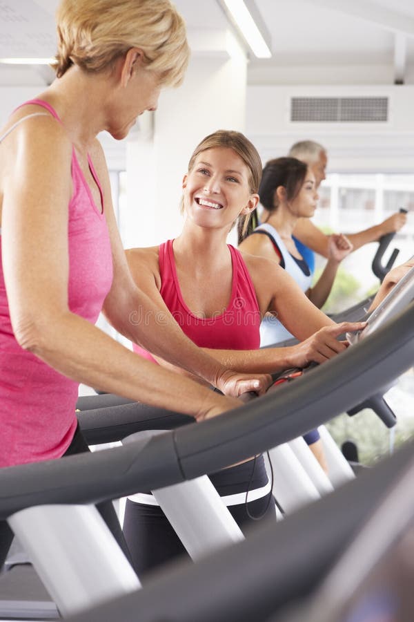 Woman on Running Machine in Gym Encouraged by Personal Trainer Stock ...