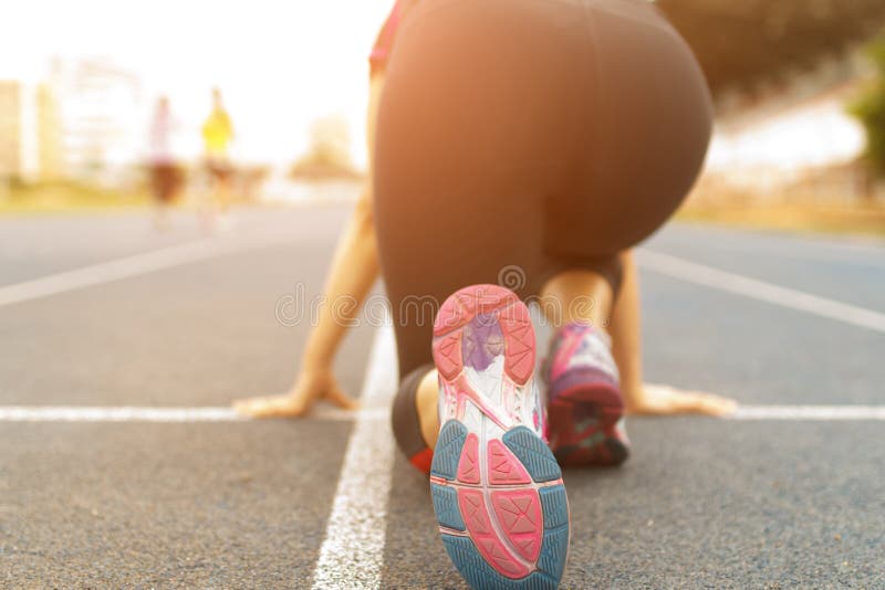Woman in Running Start Pose on the Blue Running Track in Stadium Stock ...