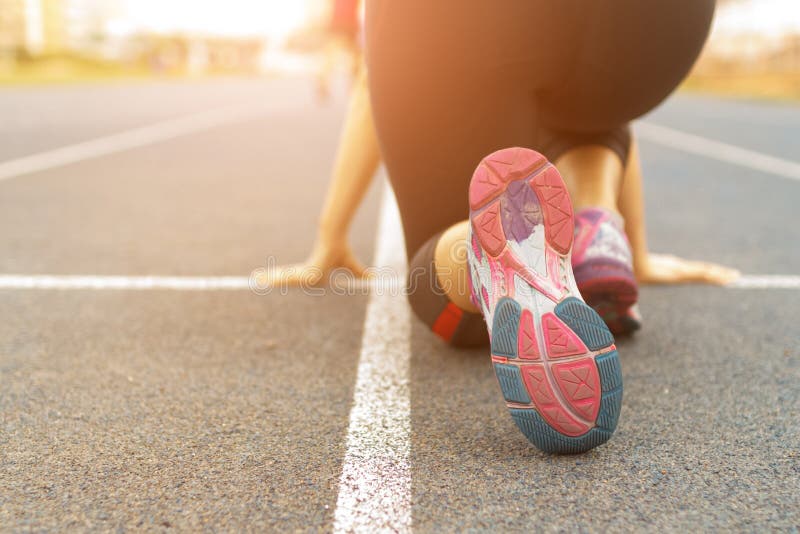 Woman in Running Start Pose on the Blue Running Track in Stadium Stock ...
