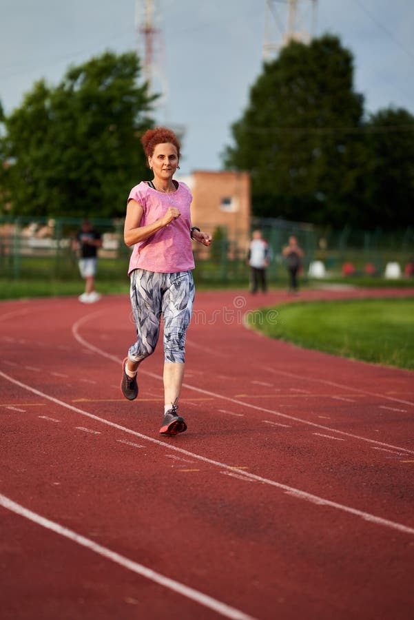 Woman running on track stock photo. Image of active - 221936086