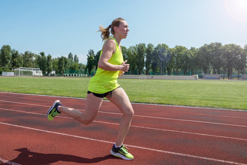 Woman runs in the stadium stock photo. Image of healthy - 252901450