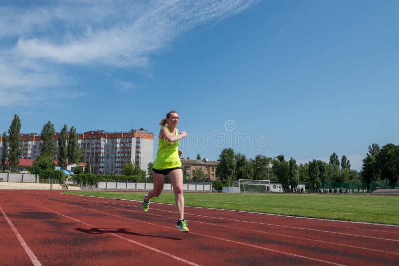 Woman runs in the stadium stock image. Image of space - 253297083