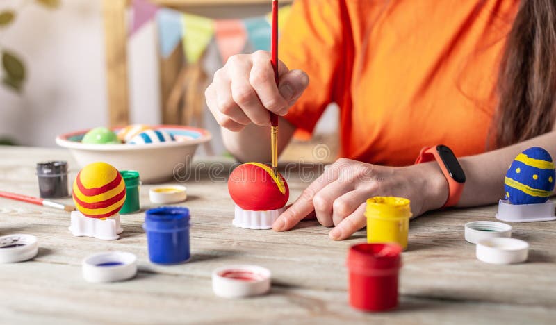 Woman`s Hand with a Brush is Drawing a Colored Pattern on an Easter Egg ...