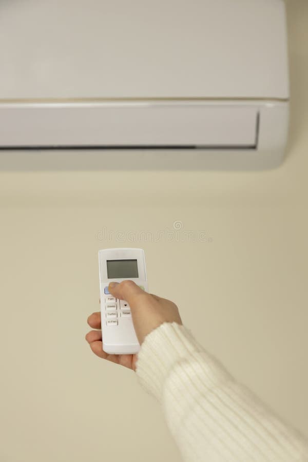 A Woman& X27;s Hand is Holding the Air Conditioner Remote Control. Air ...